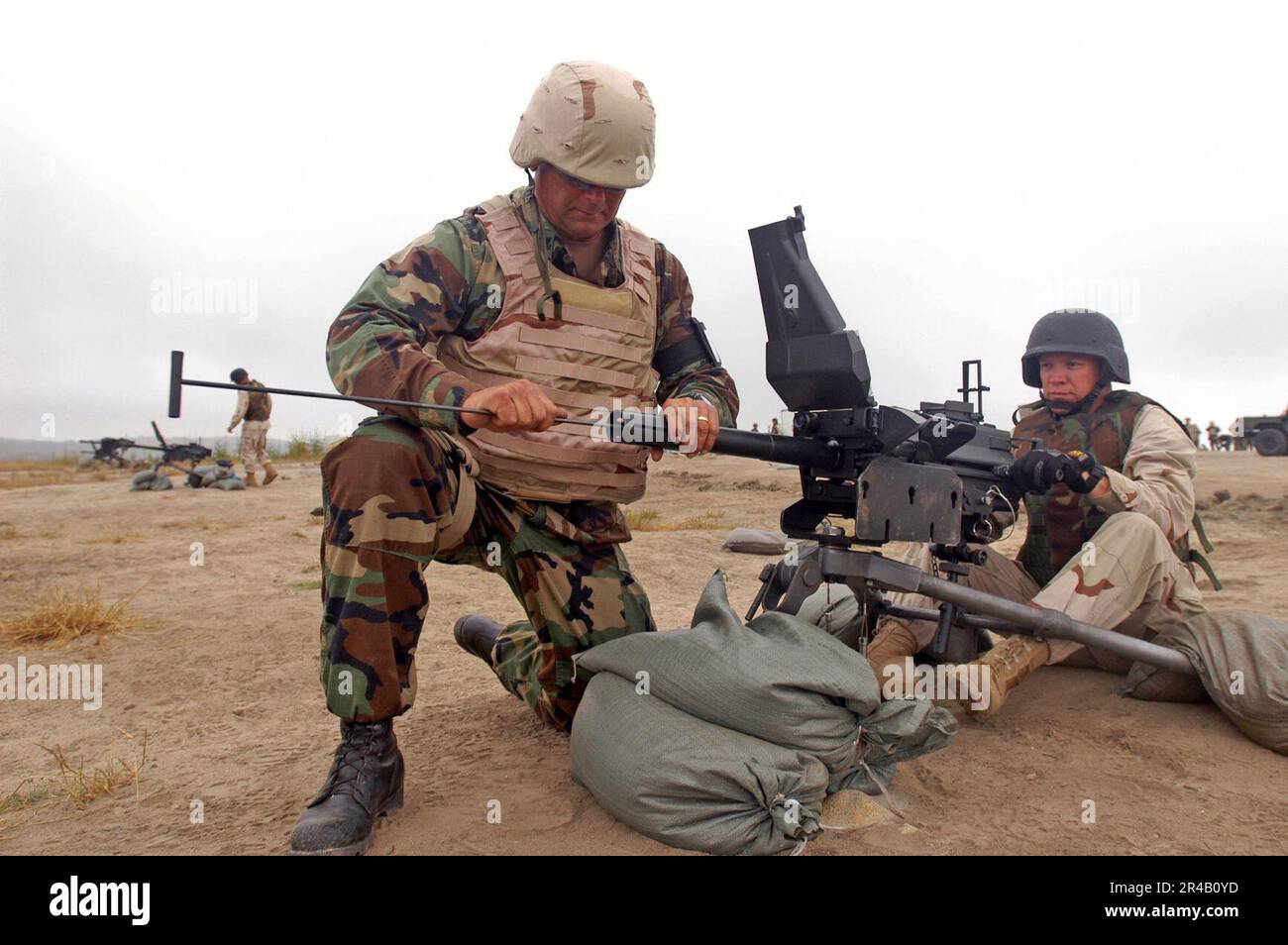 US Navy Two Sailors perform a bore check and verify target alignment ...