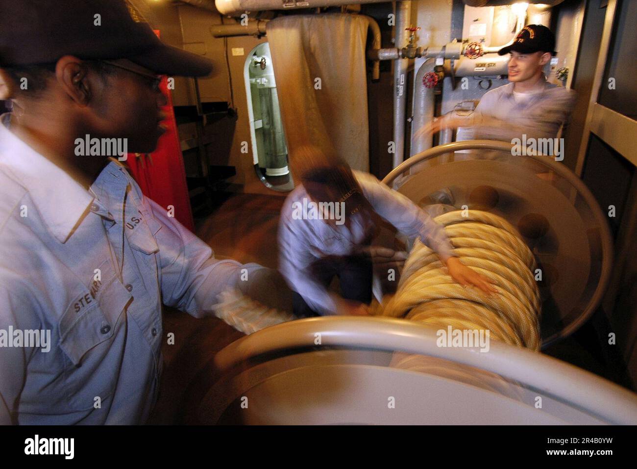 US Navy Sailors from deck department load a mooring line on to a line ...