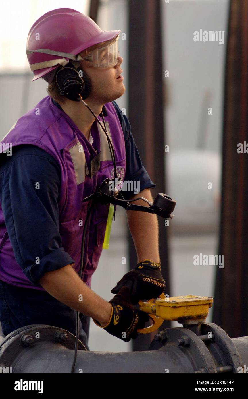 US Navy Machinist Mate 3rd class turns a fuels release valve aboard the ...