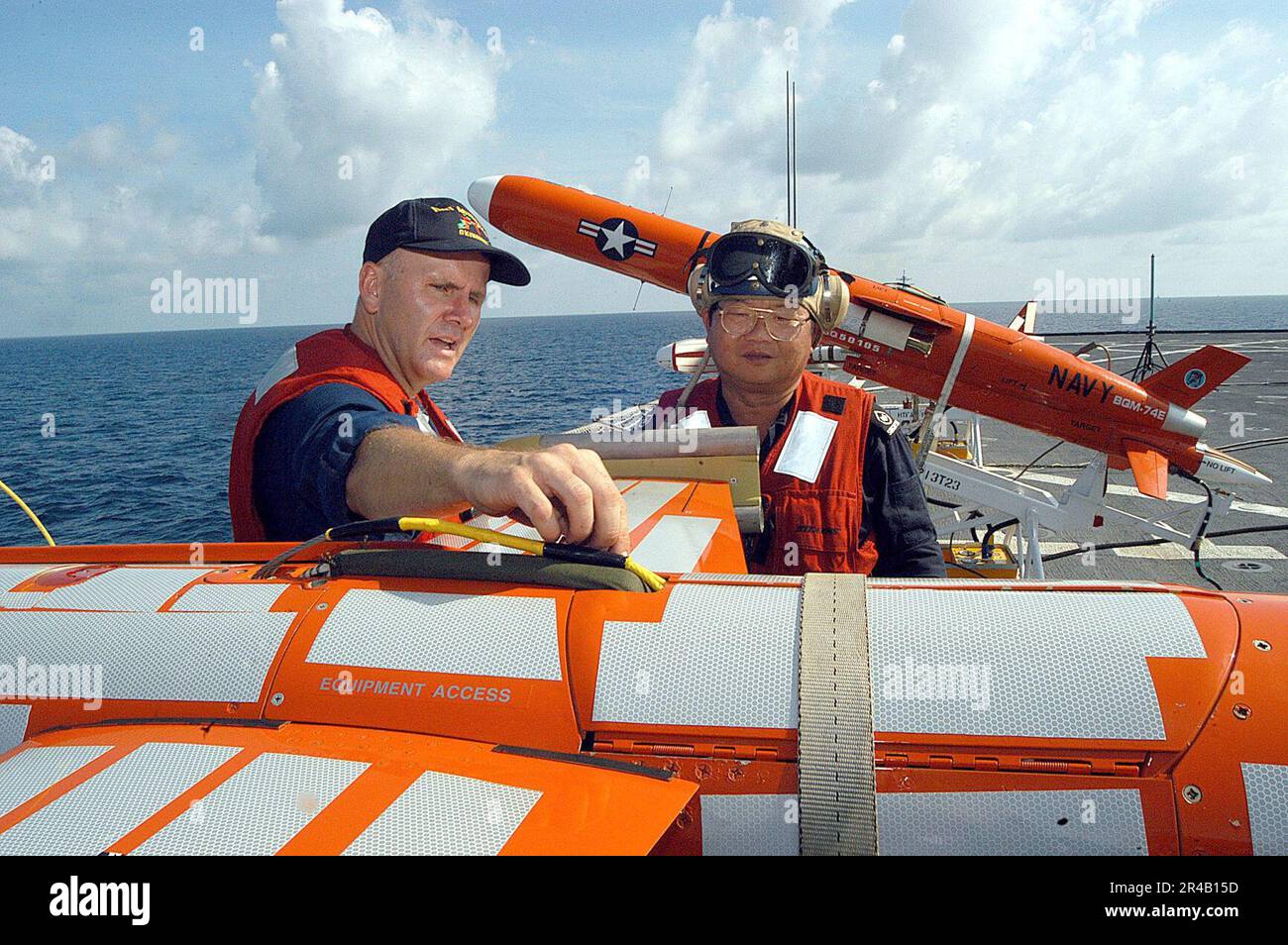 US Navy U.S. Navy Chief Warrant Officer points out the parachute doors ...