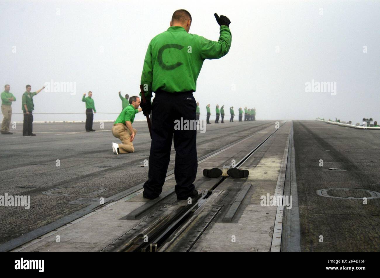 US Navy Air Boss, Capt. kneeling left, shoots off his boots from the ...