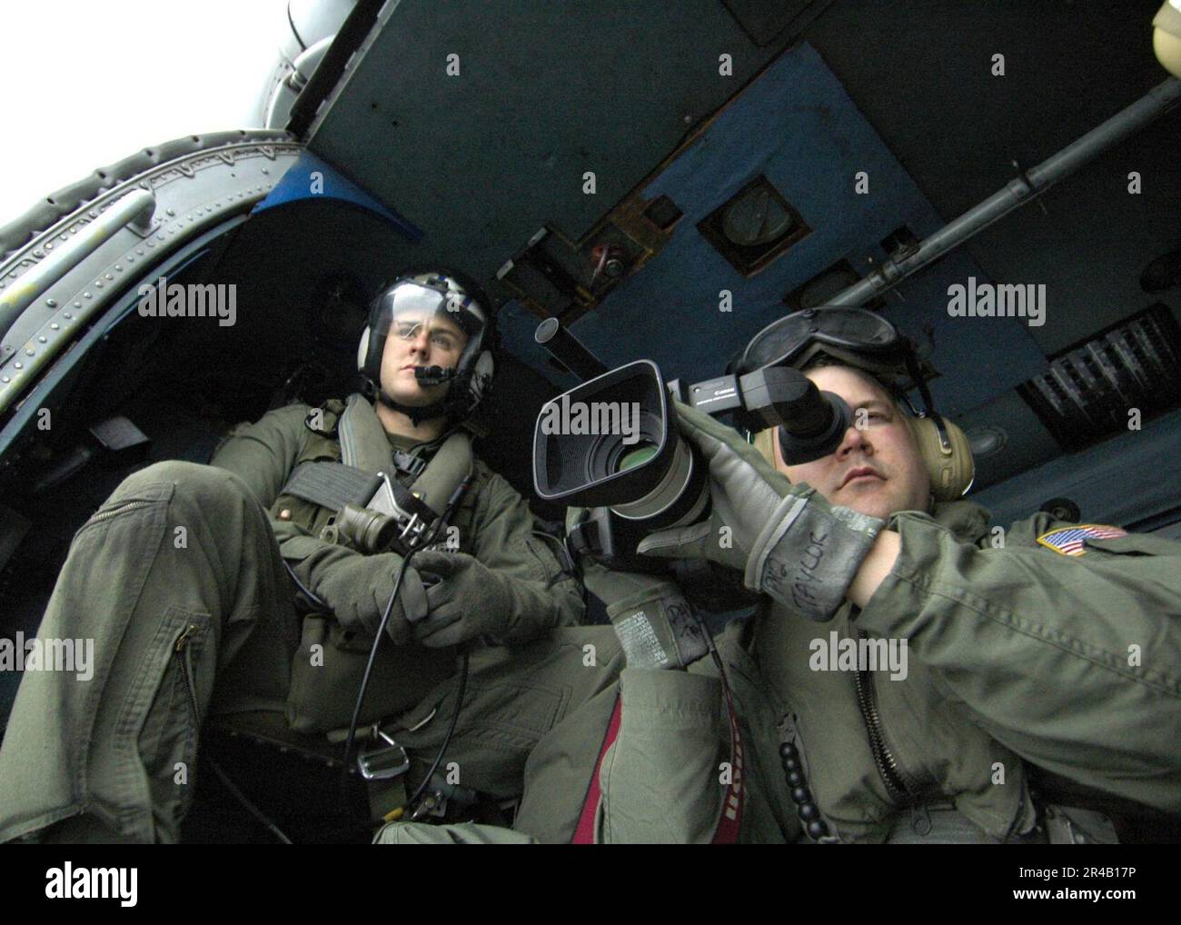 US Navy Photographer's Mate 2nd Class right, documents a passing ...