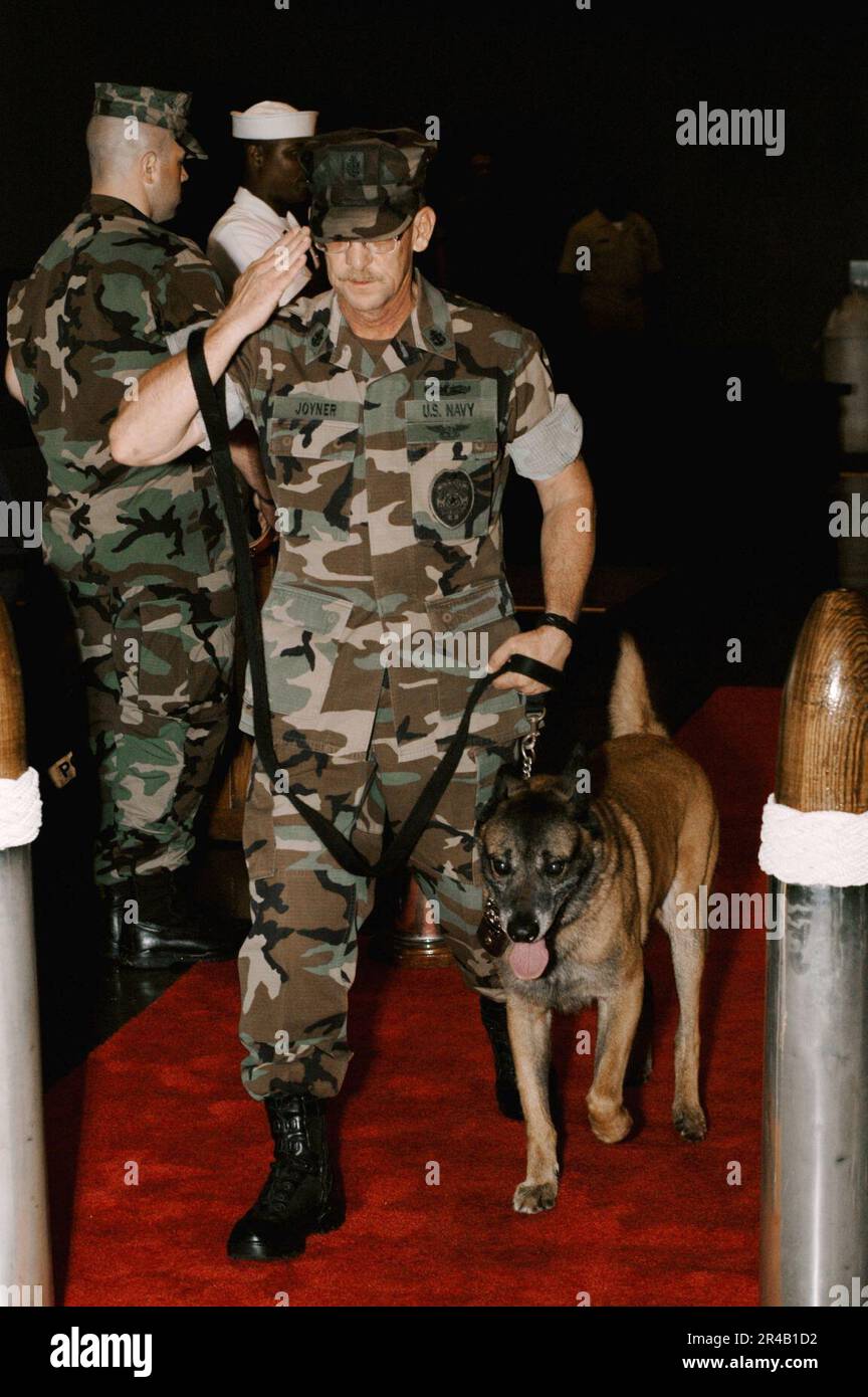 US Navy Chief Master-at-Arms salutes as he and his security dog go ...