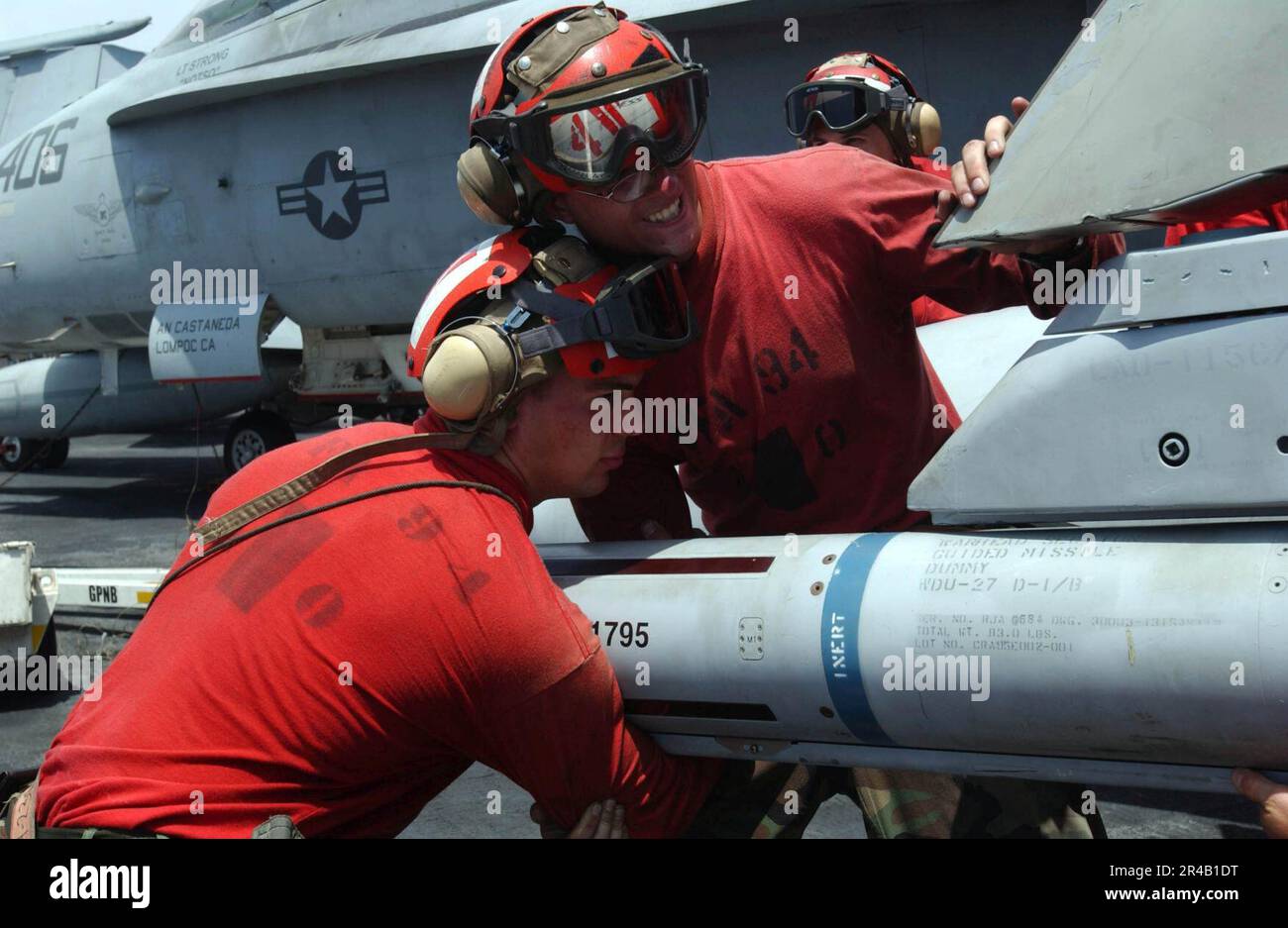 US Navy Two Aviation Ordnancemen load a Capture Air Training Missile ...