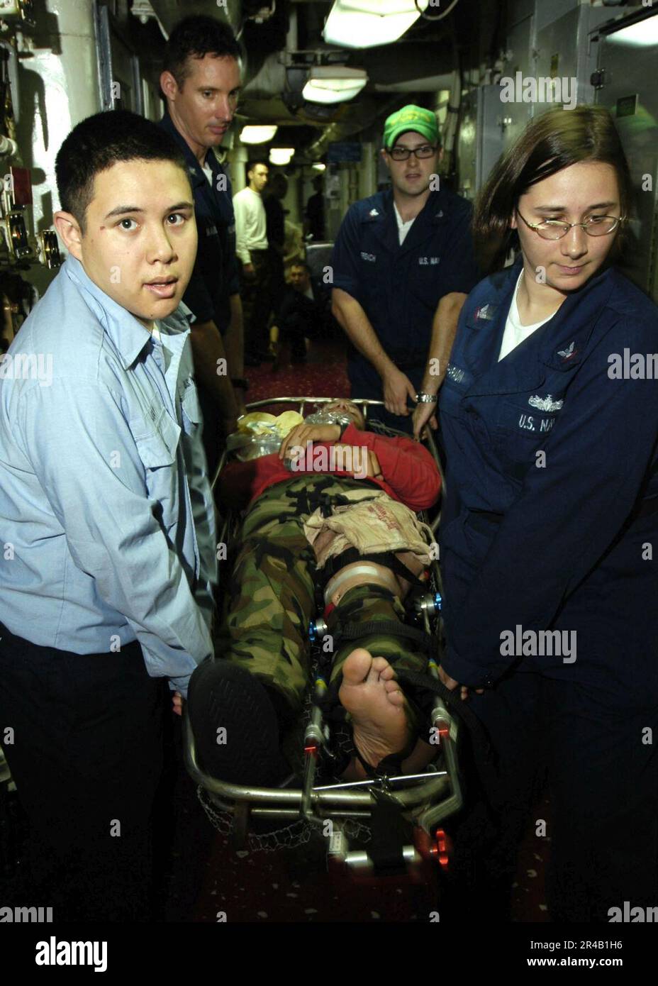 US Navy Stretcher-bearers transport a Sailor with simulated injuries to ...