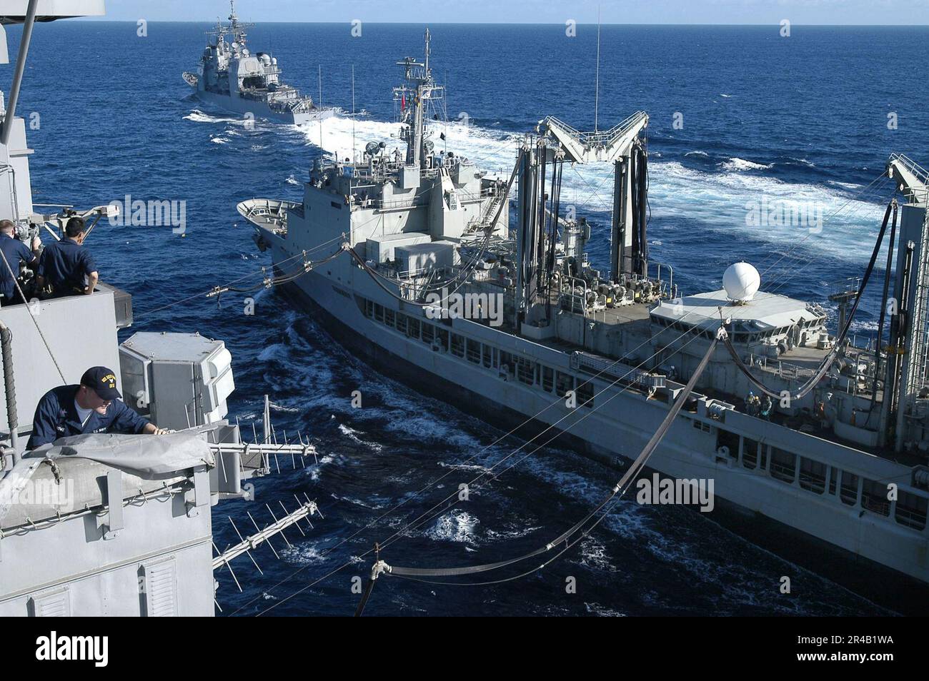 US Navy Sailors aboard USS Kitty Hawk (CV 63) observe a replenishment ...