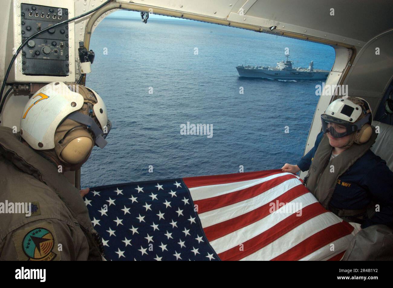US Navy Lt. Col left, and Lt. j.g. displays the American flag while ...