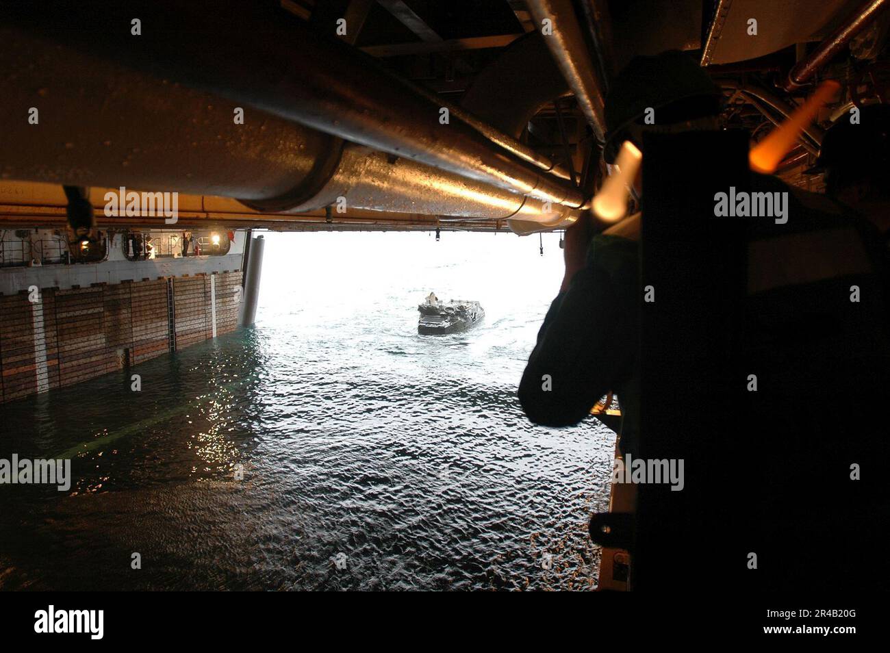 US Navy Seaman signals an amphibious assault vehicle as it enters the ...