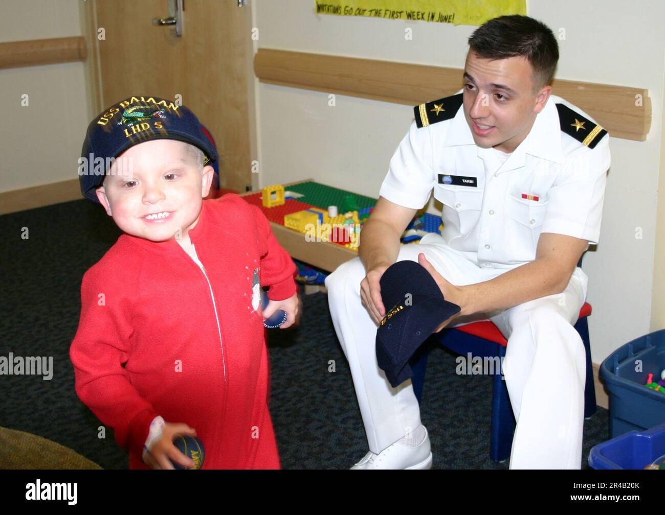 US Navy Boston College graduate, Ens. presents a ball cap to a young ...