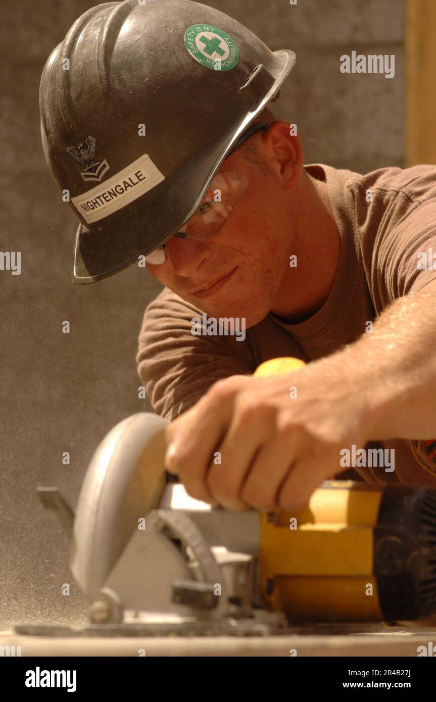 US Navy Builder 2nd Class cuts through sheets of wood used as a mould ...