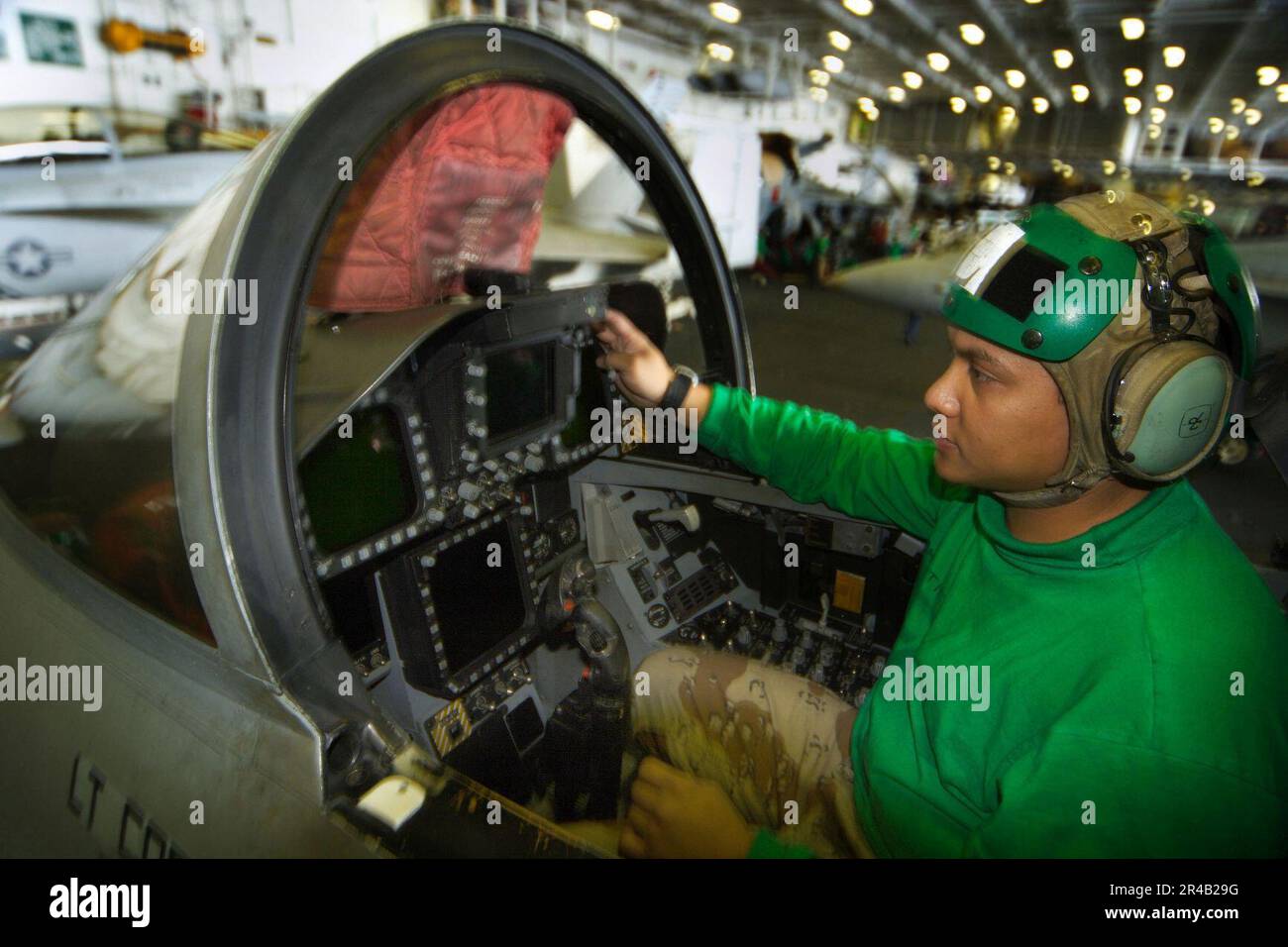 US Navy Aviation Structural Mechanic 2nd Class inspects the cockpit of ...
