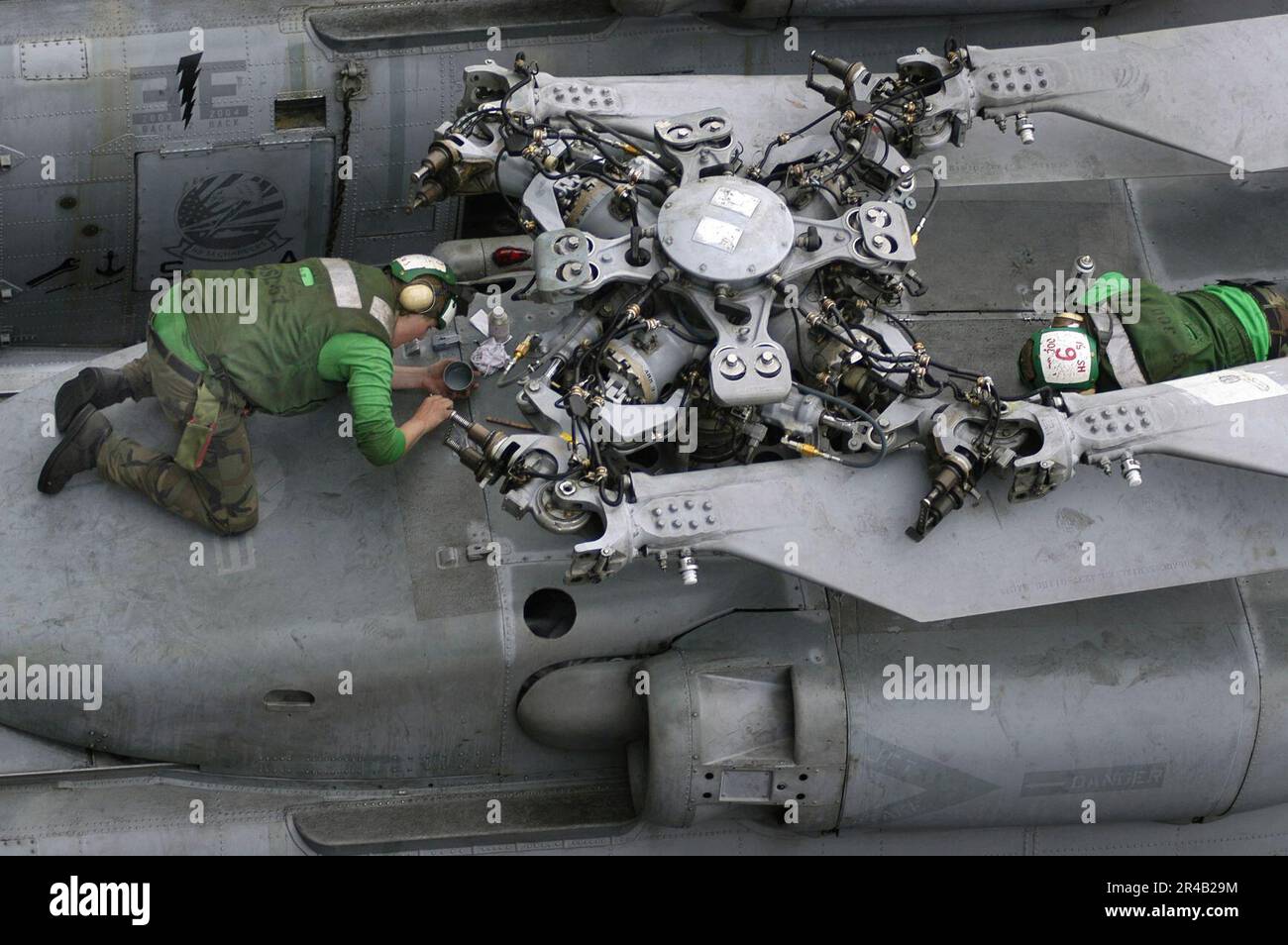 US Navy Sailors perform routine corrosion control maintenance on an SH ...