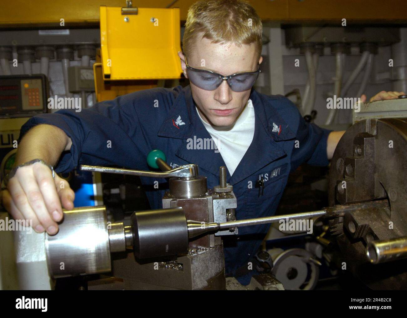 US Navy Machinery Repairman 3rd Class uses a lathe machine to turndown ...