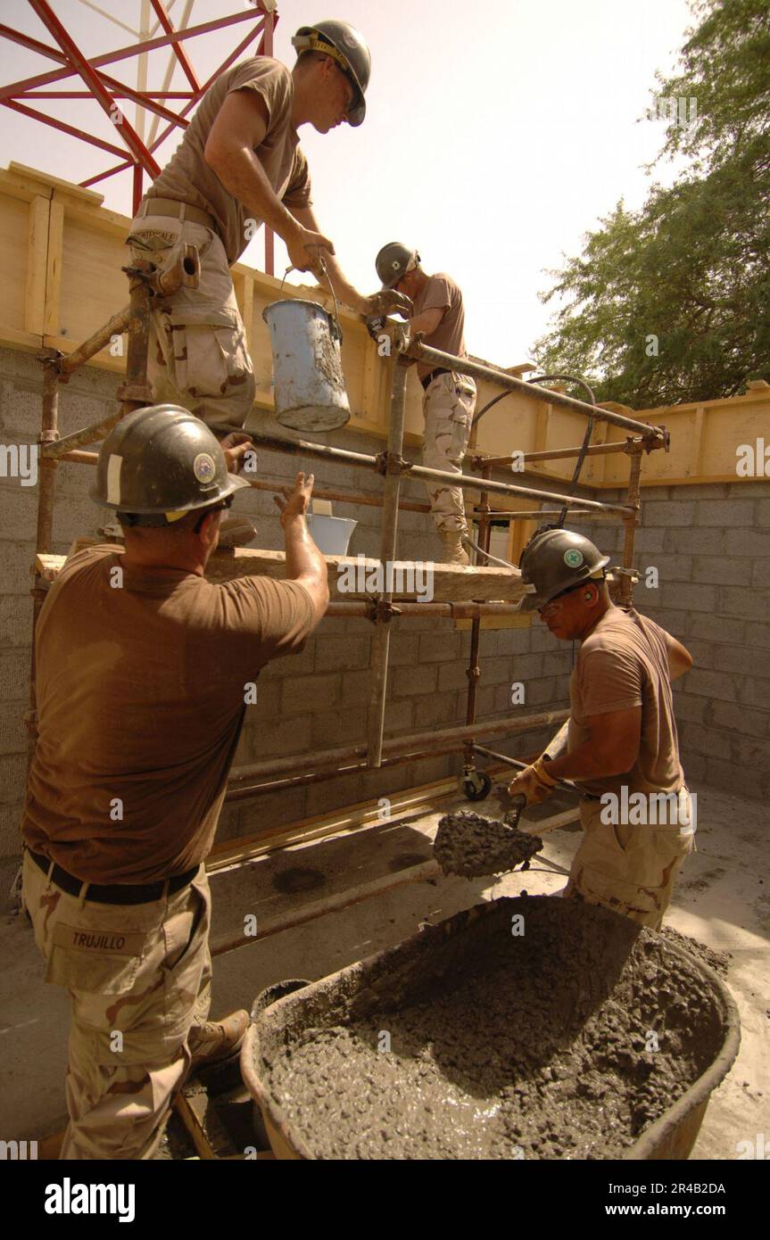 US Navy Seabees assigned to Naval Mobile Construction Battalion Five (NMCB-5) pass concrete in ...
