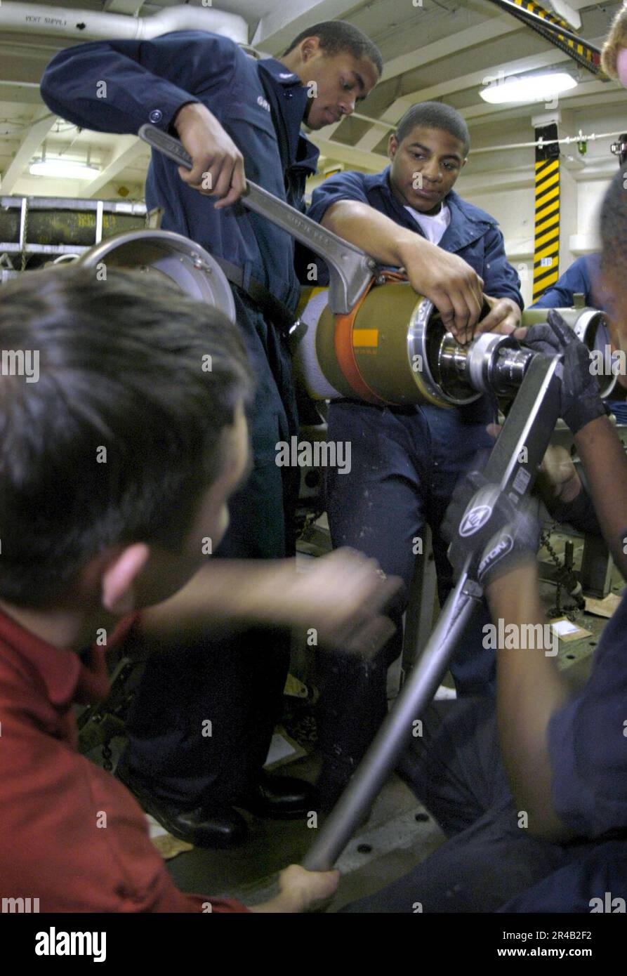 US Navy Sailors assigned to the Weapons Department attach a laser ...