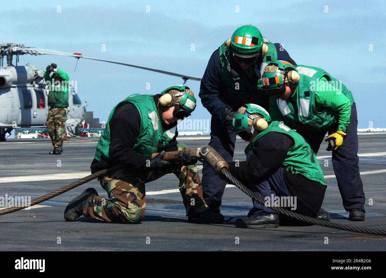 US Navy Air Department's V-2 arresting gear crew members replace a ...