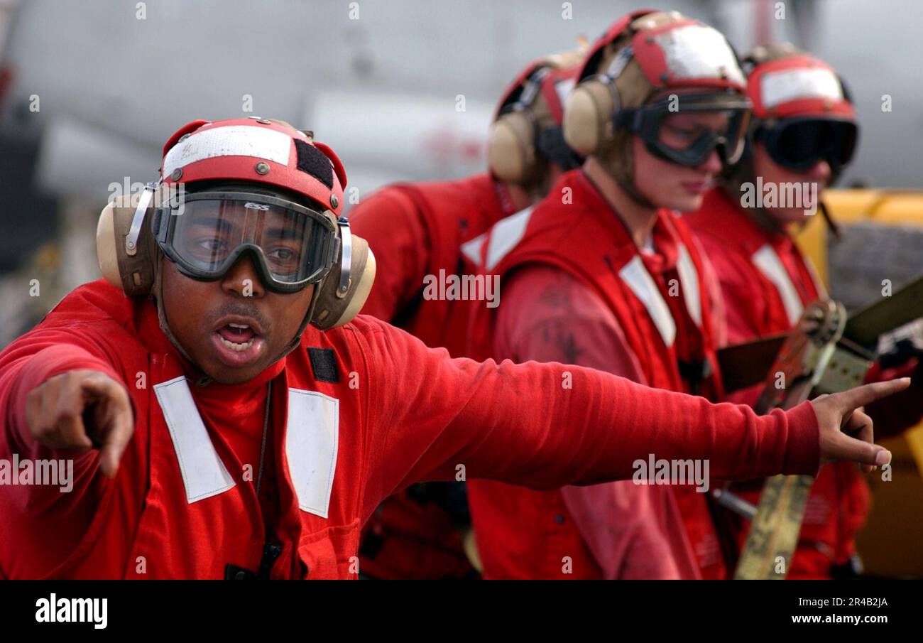 US Navy Aviation Boatswain's Mate 3rd Class shouts instructions to ...