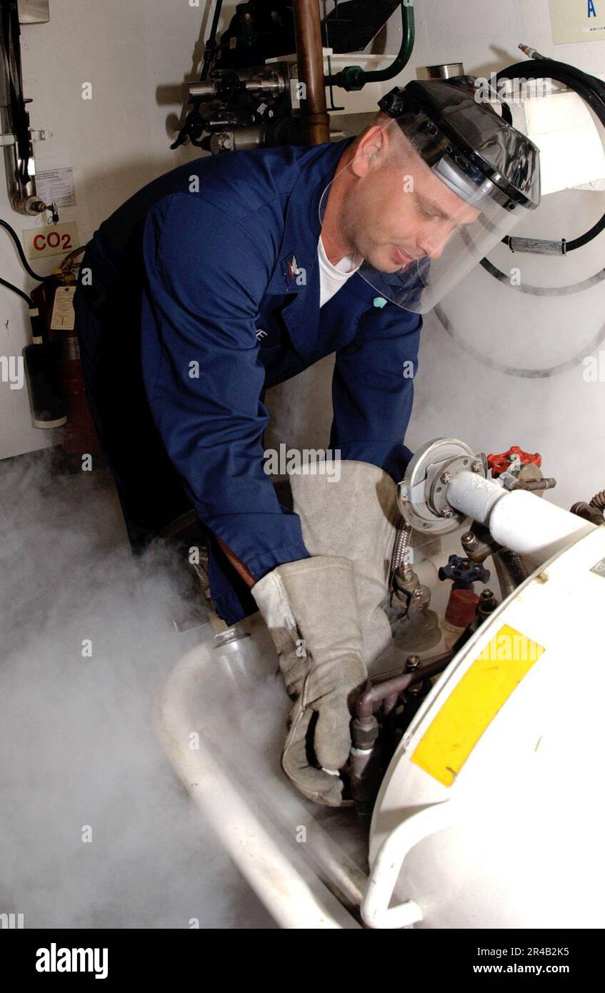 US Navy Machinist's Mate 3rd Class transfers liquid oxygen (LOX) into a ...