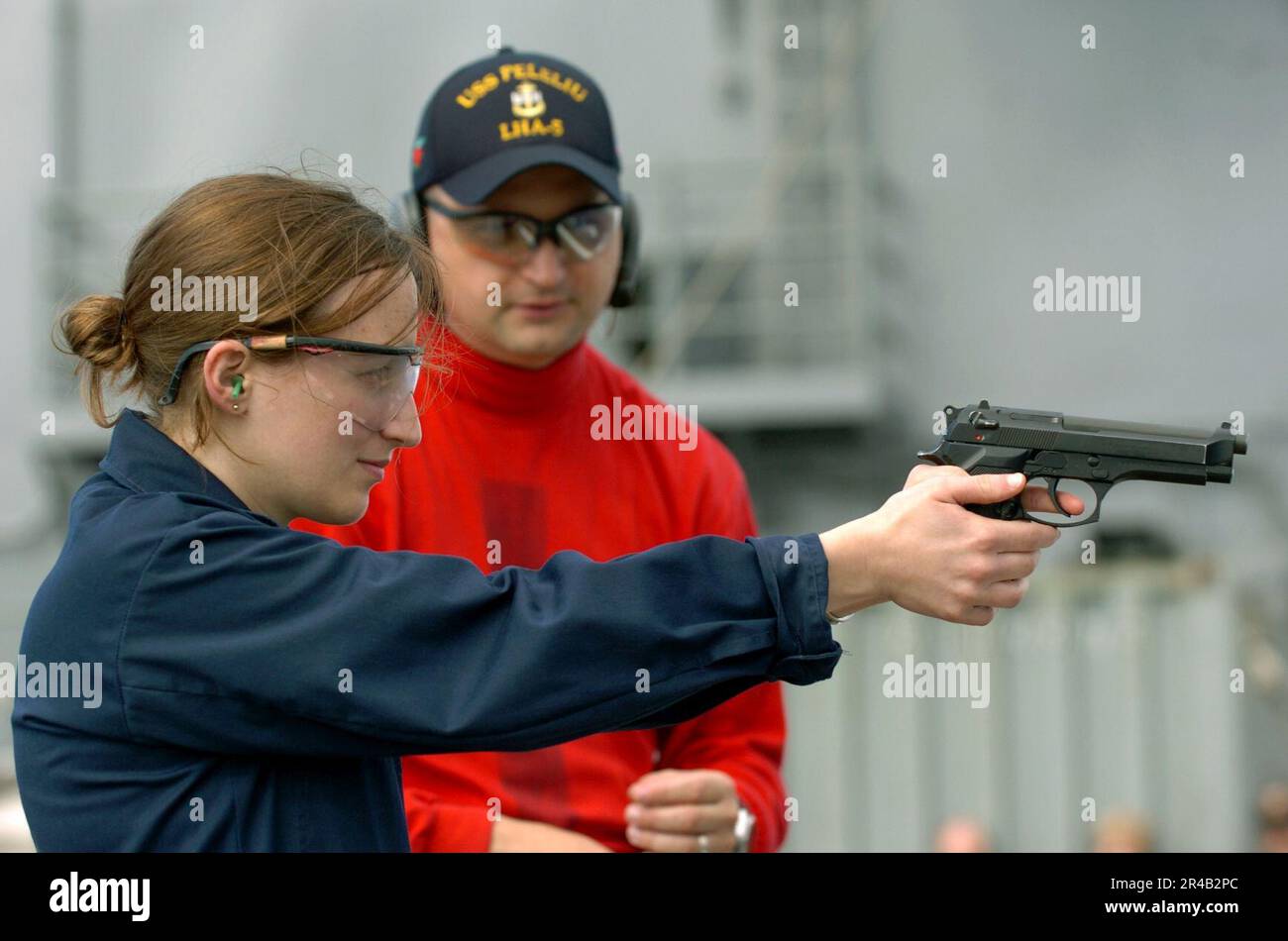 US Navy Chief Gunner's Mate instructs Ens. on the proper firing ...