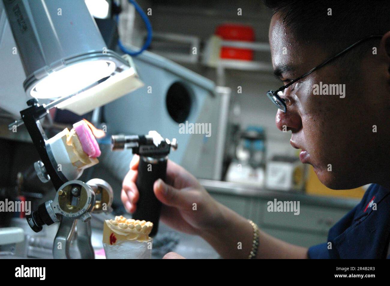 US Navy Dental Technician 3rd Class sculpts a mouth guard for a ...