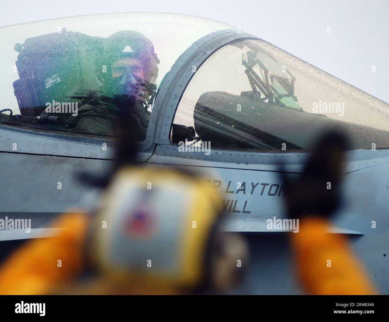 US Navy A pilot observes preflight hand signals prior to launching from ...