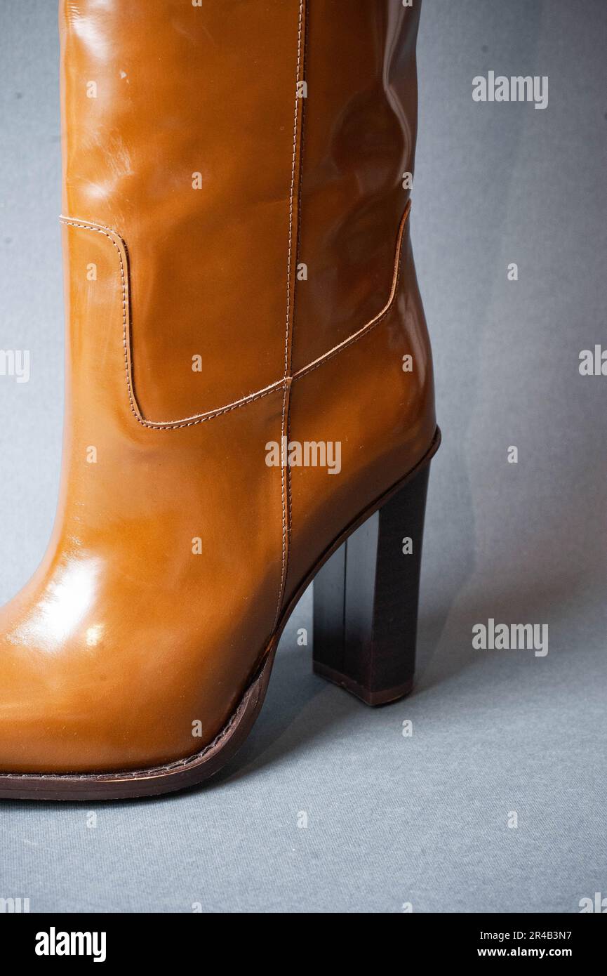 A close-up image of a brown leather-textured boot with laces lying flat ...