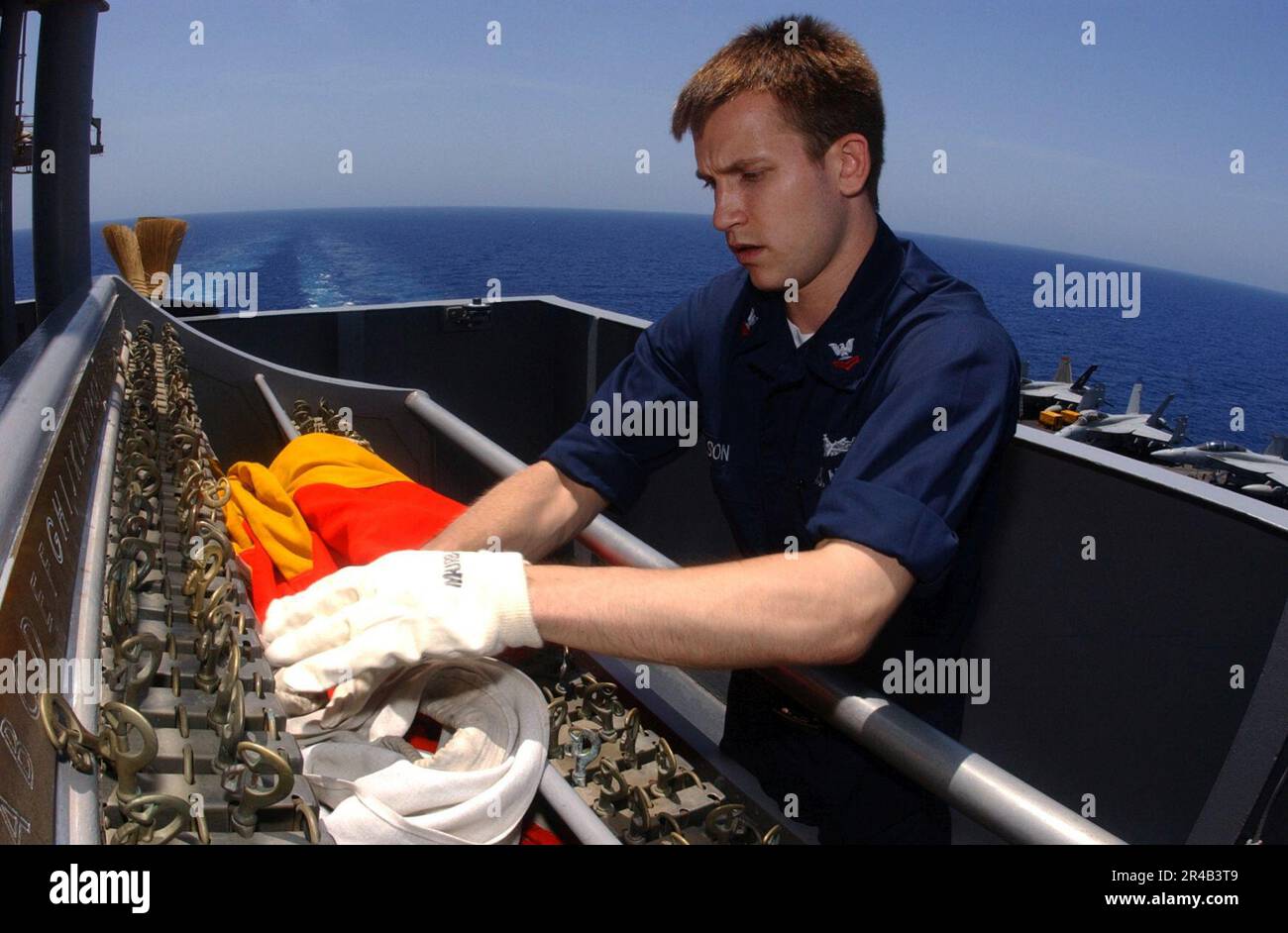 US Navy Quartermaster 2nd Class QM2 stows signal flags on the Signal ...