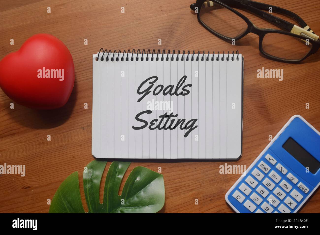 A blank white notepad with a heading of 'goals setting' and various ...