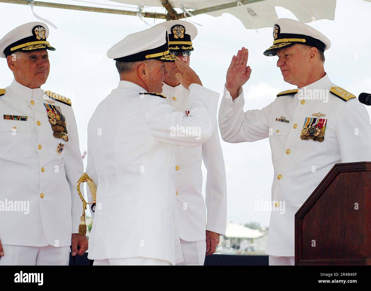 US Navy Adm. Walter F. Doran, left, renders a salute as Adm. Gary ...