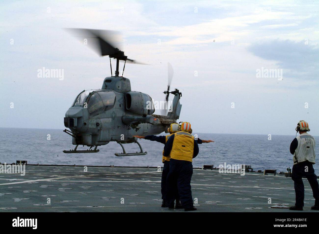 US Navy Lt.j.g. is steadied by Storekeeper Seaman as he directs an ...