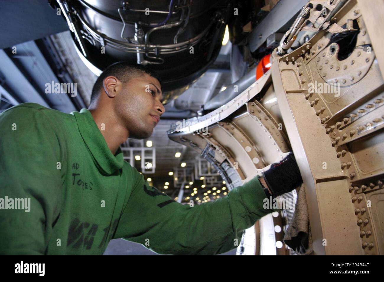 US Navy Aviation Machinist's Mate 3rd Class cleans grease out of an F-A ...