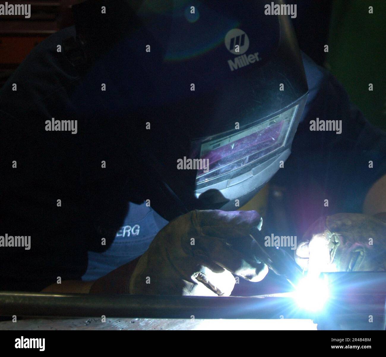 US Navy Hull Maintenance Technician Fireman welds together piping in ...