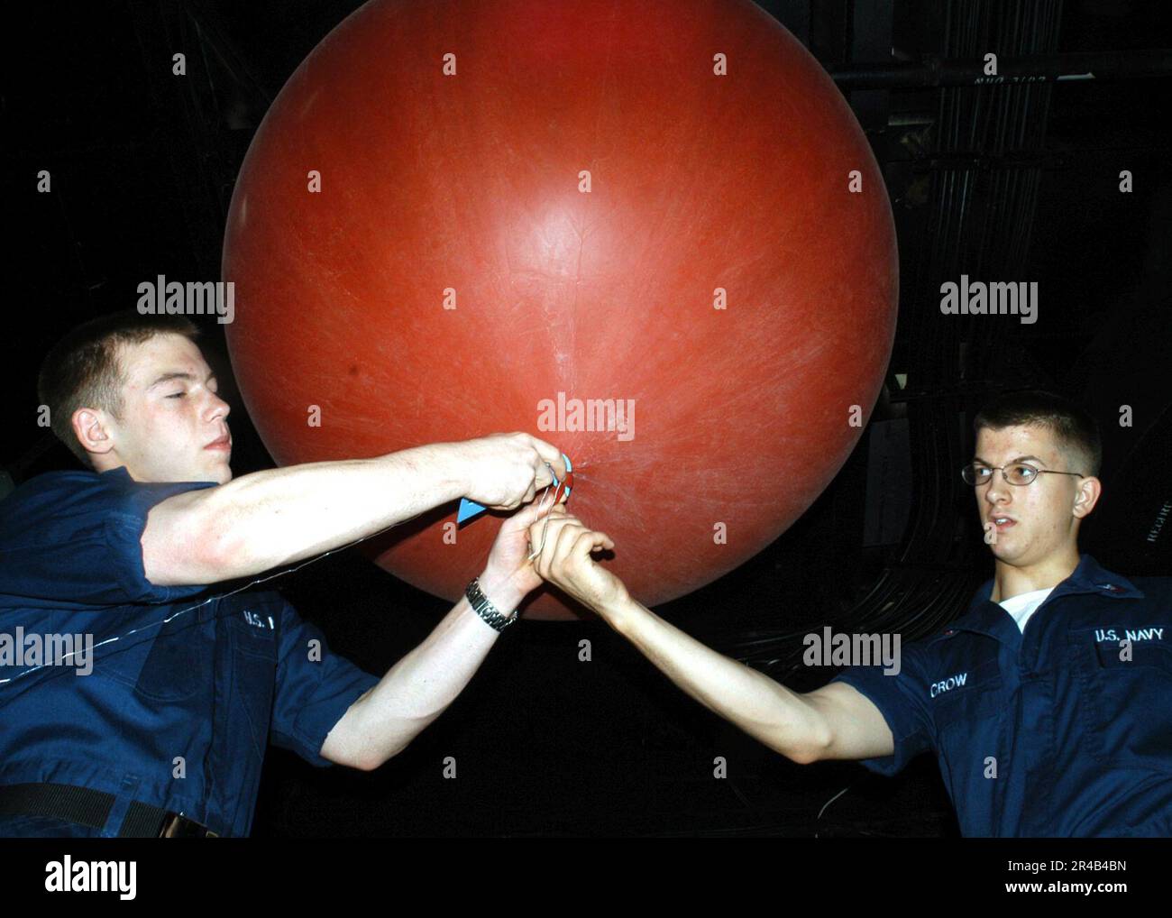 US Navy Aerographer's Mates 3rd Class fill a weather balloon and ...