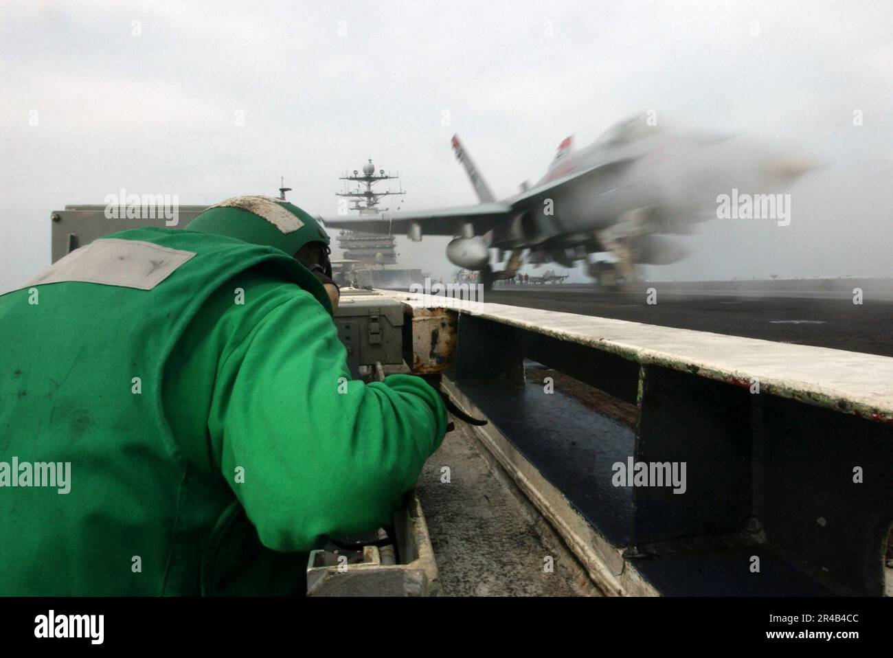 US Navy A bow safety observer ducks at his station as an F-A-18C Hornet ...