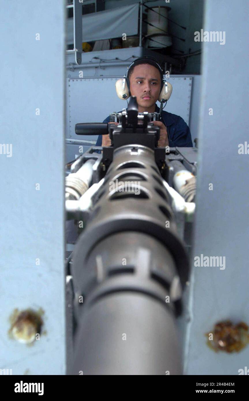 US Navy Airman mans a .50 caliber machine gun mount on the fantail ...