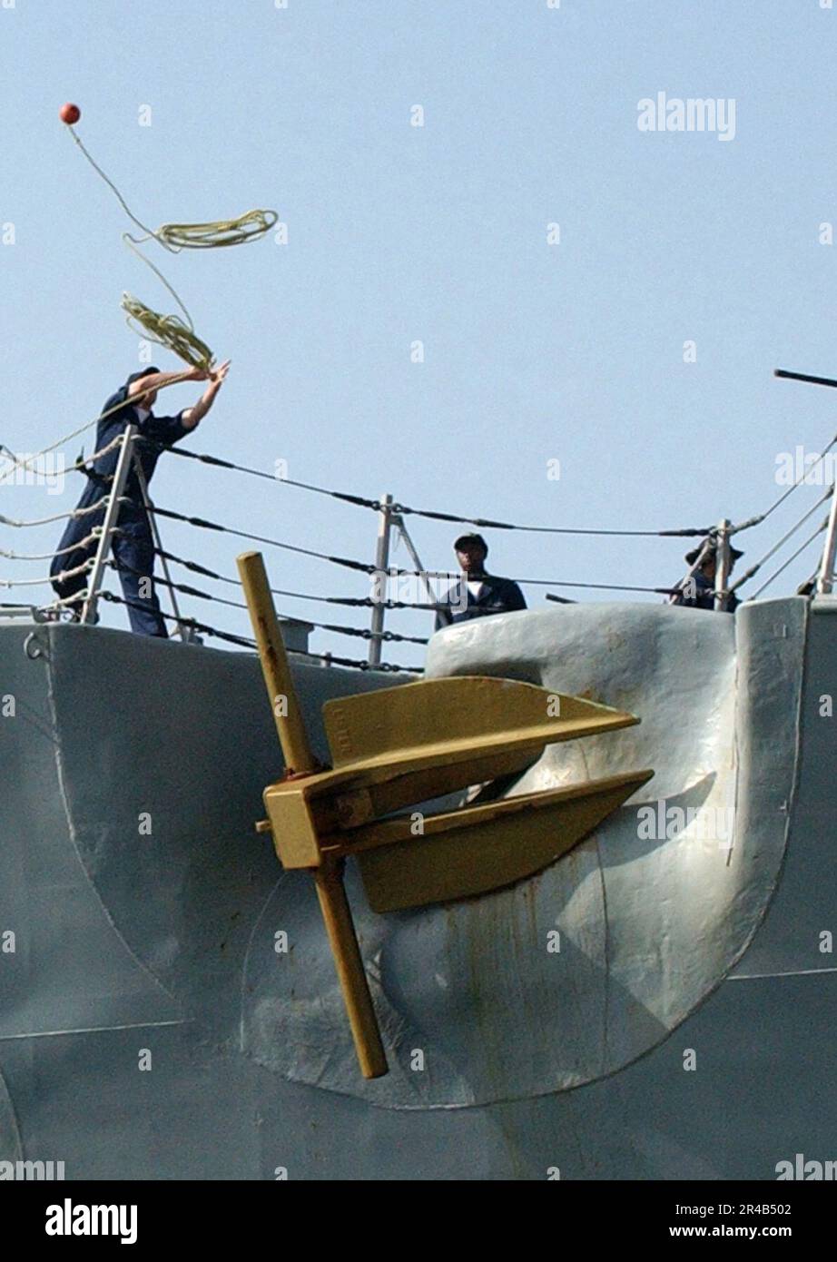 US Navy A Sailor sends over a heaving line to the pier for the bow line ...