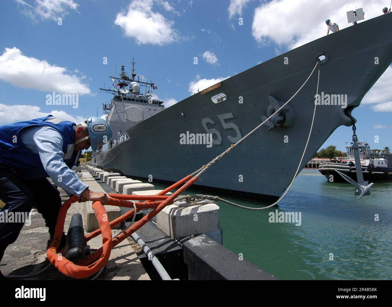 US Navy Boatswain's Mate 3rd Class casts off a mooring line as the ...