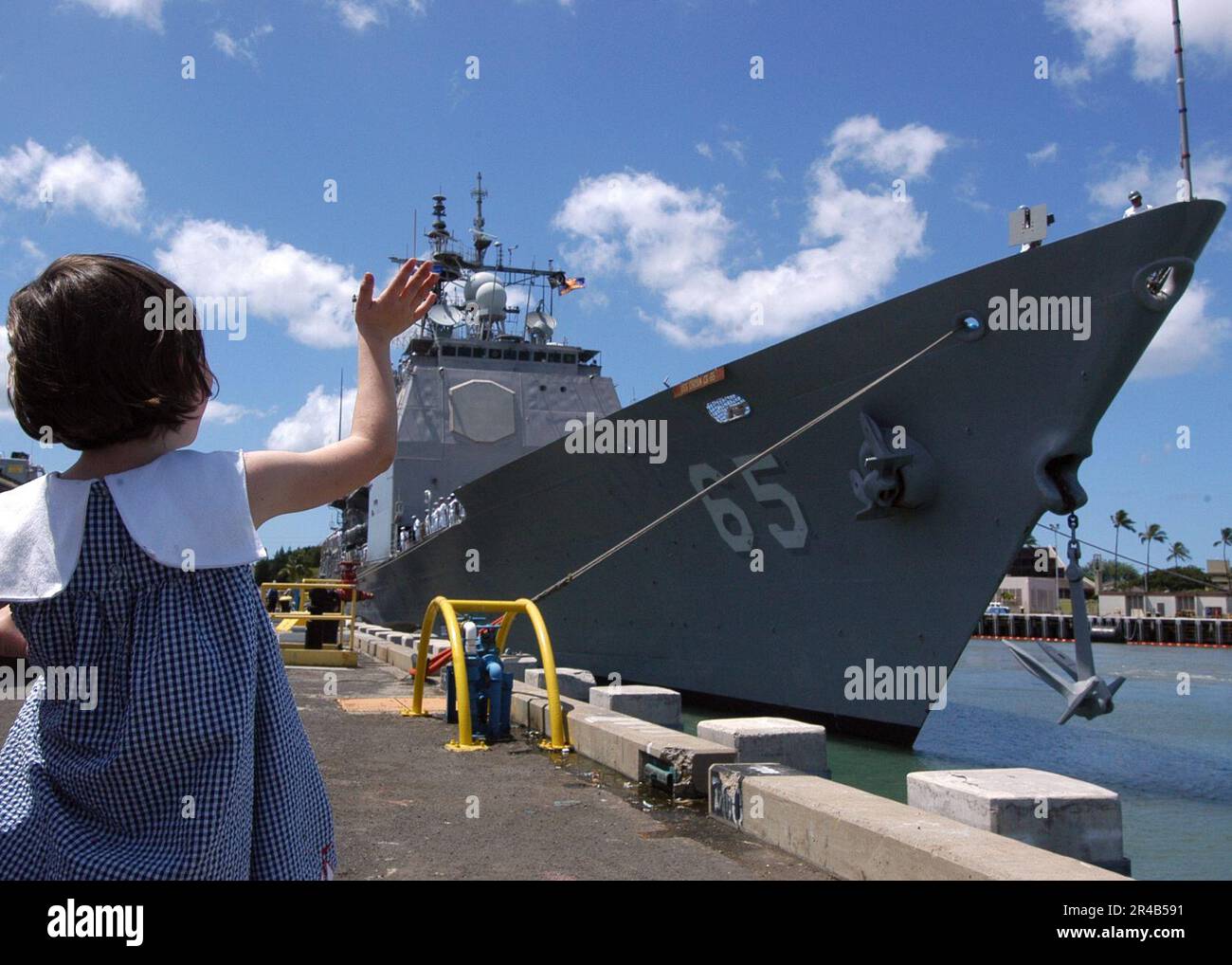 US Navy A family member waves goodbye as the guided missile cruiser USS ...