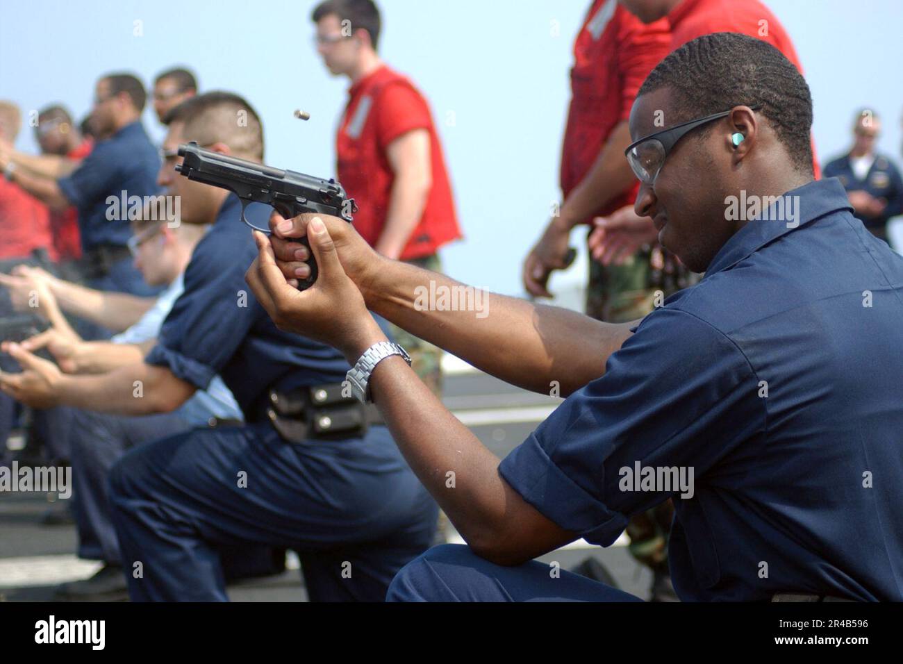 US Navy Aviation Ordnanceman Airman fires a 9mm handgun at the 25 meter ...