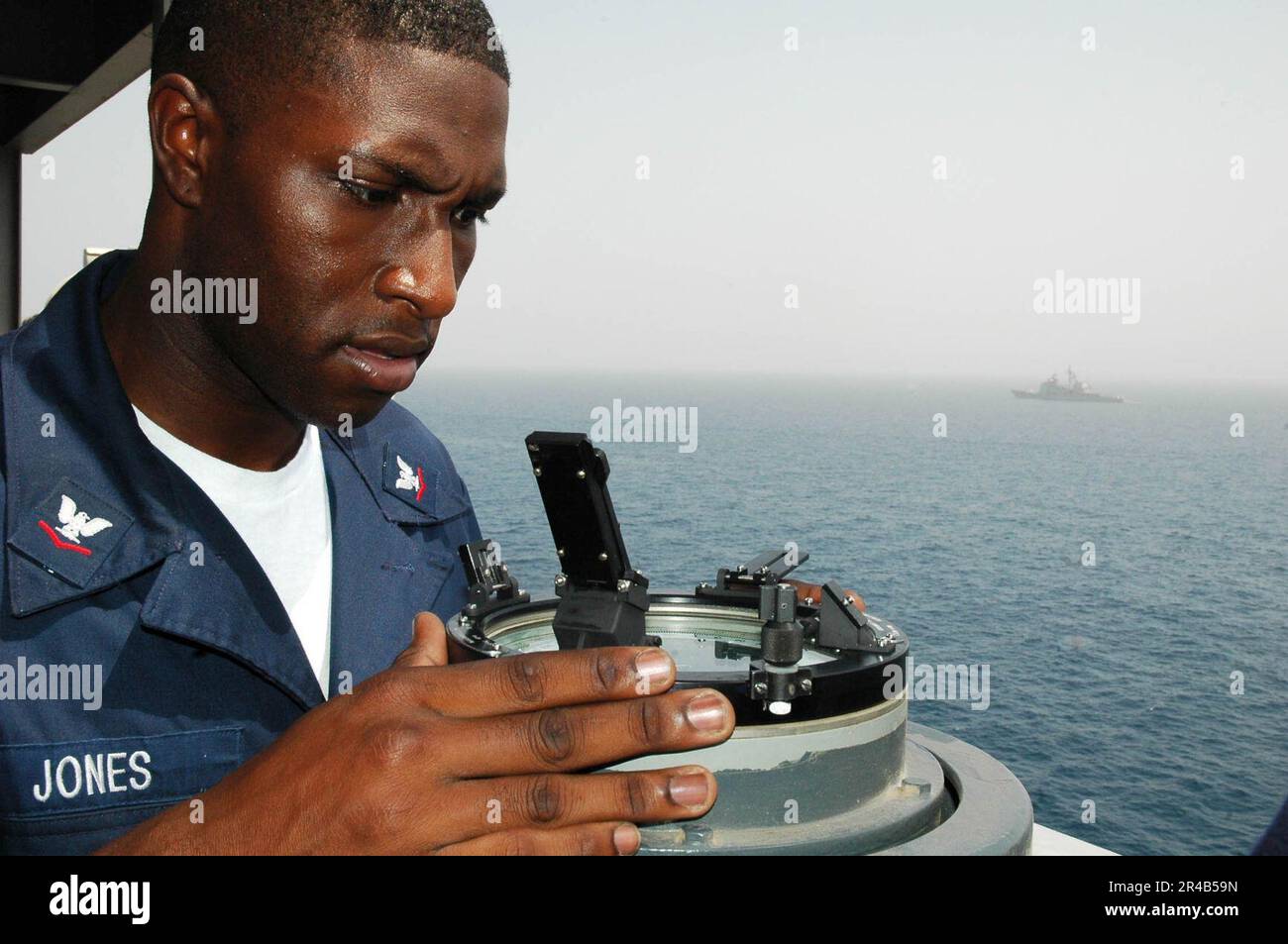 US Navy Quartermaster 3rd Class takes an azimuth reading on the O-10 ...