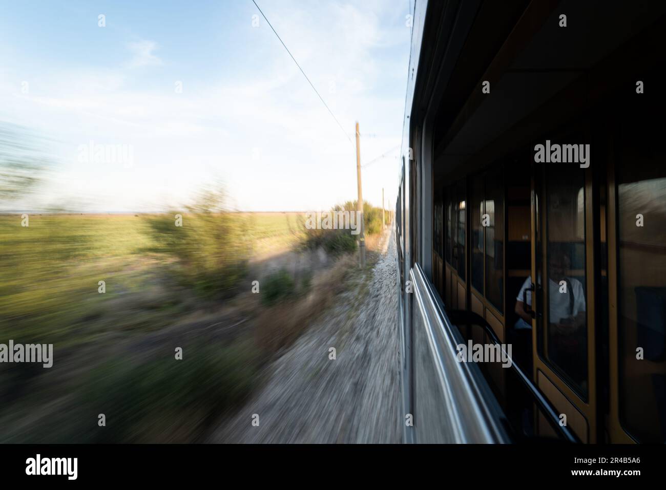 A high-resolution image of a train window with a blurred view of ...