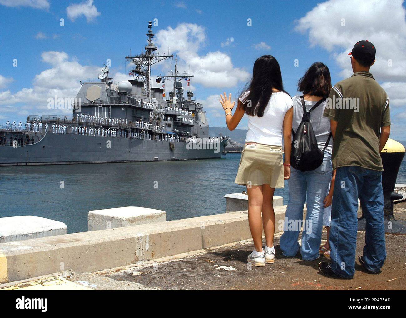 US Navy Loved ones stand on the pier as they wave goodbye to the crew ...