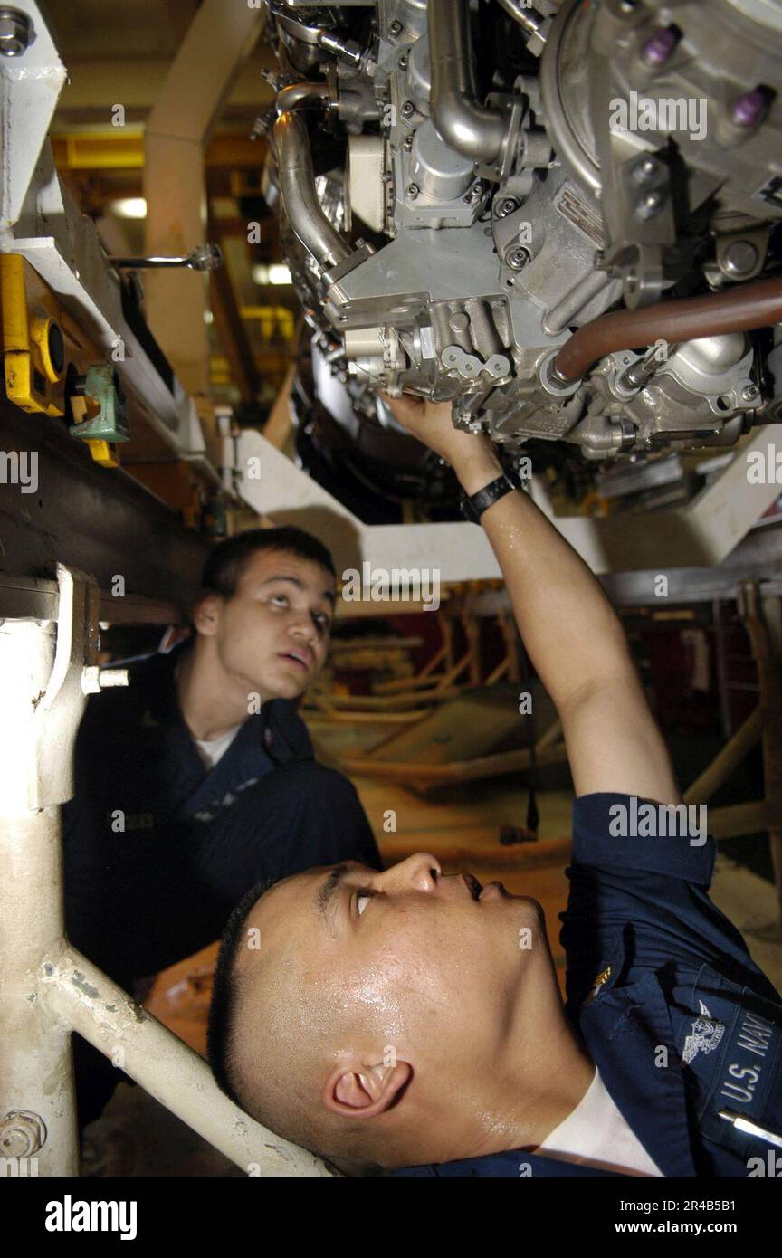 US Navy Aviation Machinist's Mate 1st Class foreground, performs ...