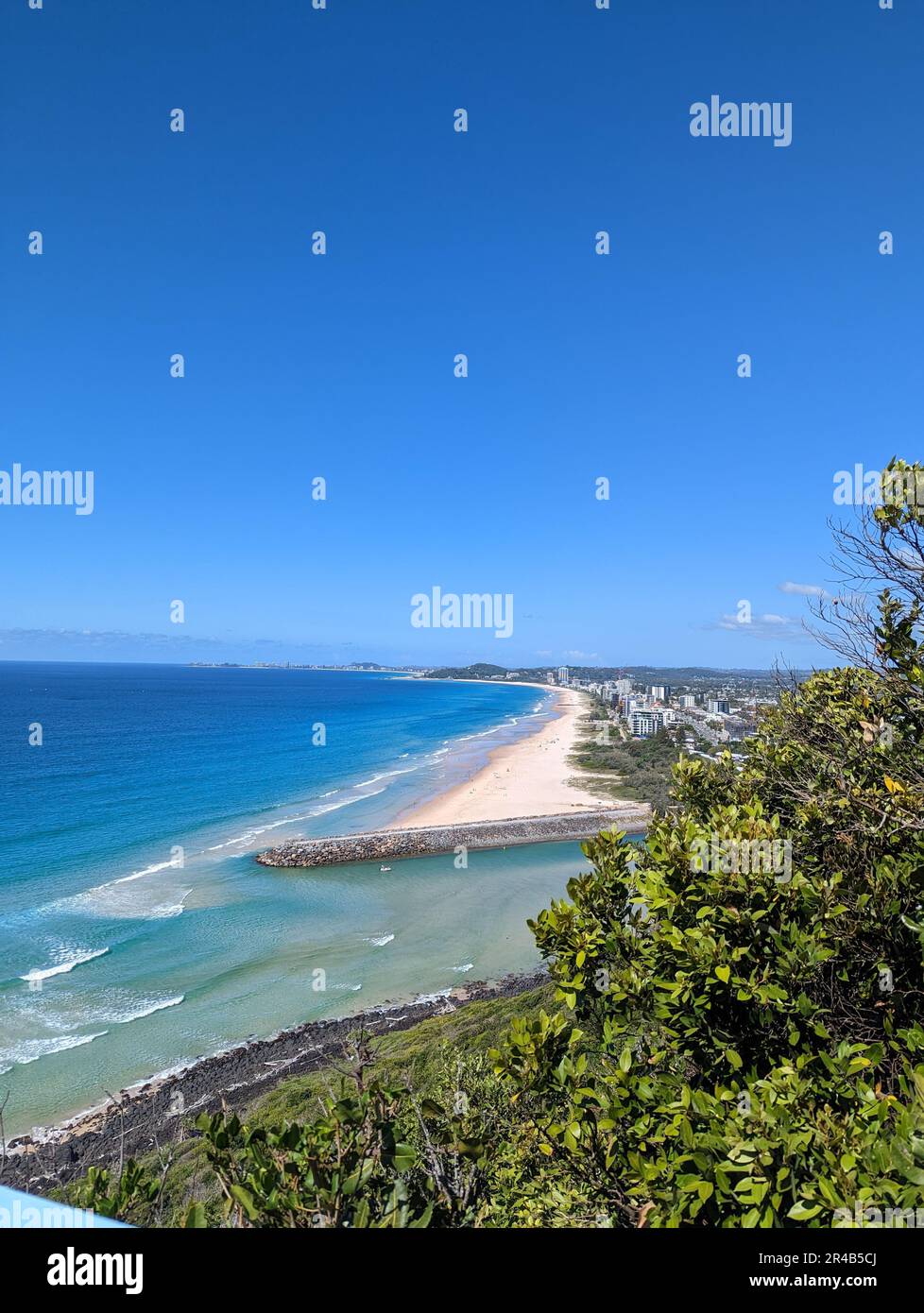 An aerial view of a white sand beach and a deep blue ocean from the top ...