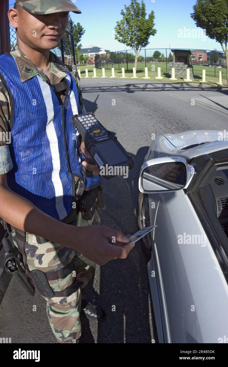 US Navy Master-at-Arms 3rd Class scans a military identification card ...