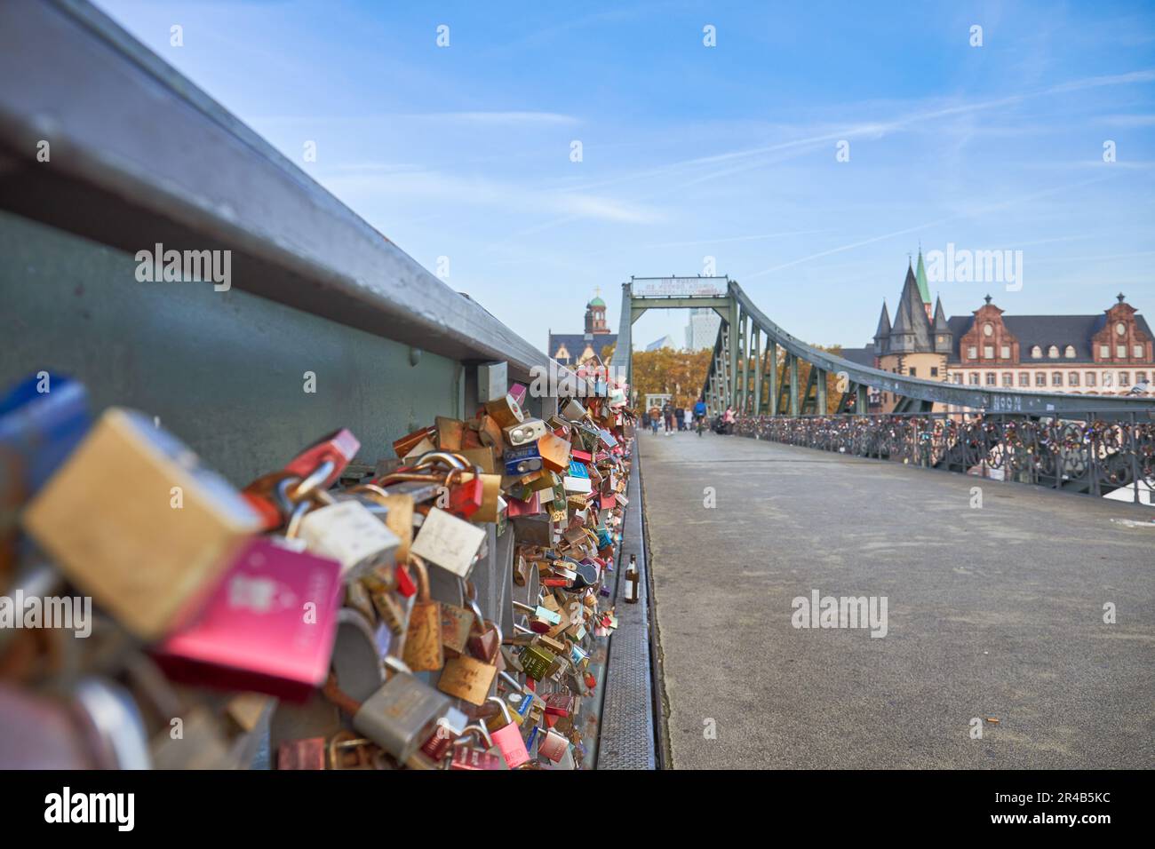 A romantic bridge with many love locks attached, spanning a body of ...