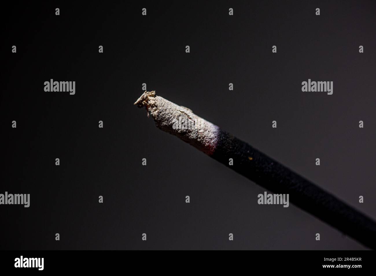A close-up image of a single matchstick that has been used and is now ...