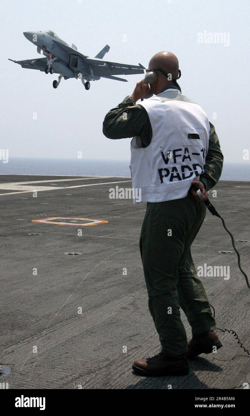 US Navy Landing Signal Officer (LSO) watches as an F-A-18E Super Hornet ...