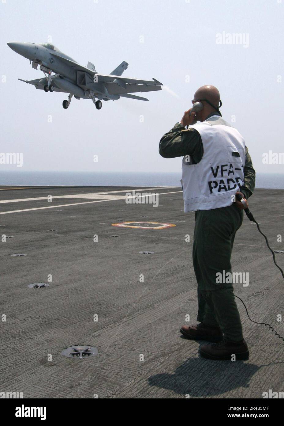 US Navy A landing signal officer (LSO) watches as an F-A-18E Super ...