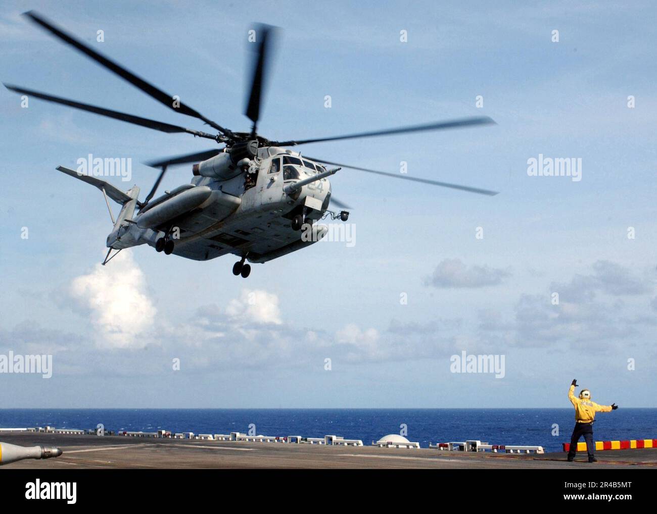 US Navy A Landing Signal Enlisted (LSE) guides a CH-53E Super Stallion ...